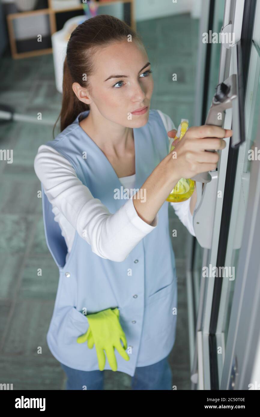 female janitor cleaning the window Stock Photo - Alamy