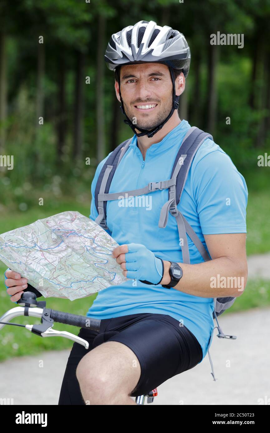 cyclist man checking map and looking around Stock Photo - Alamy