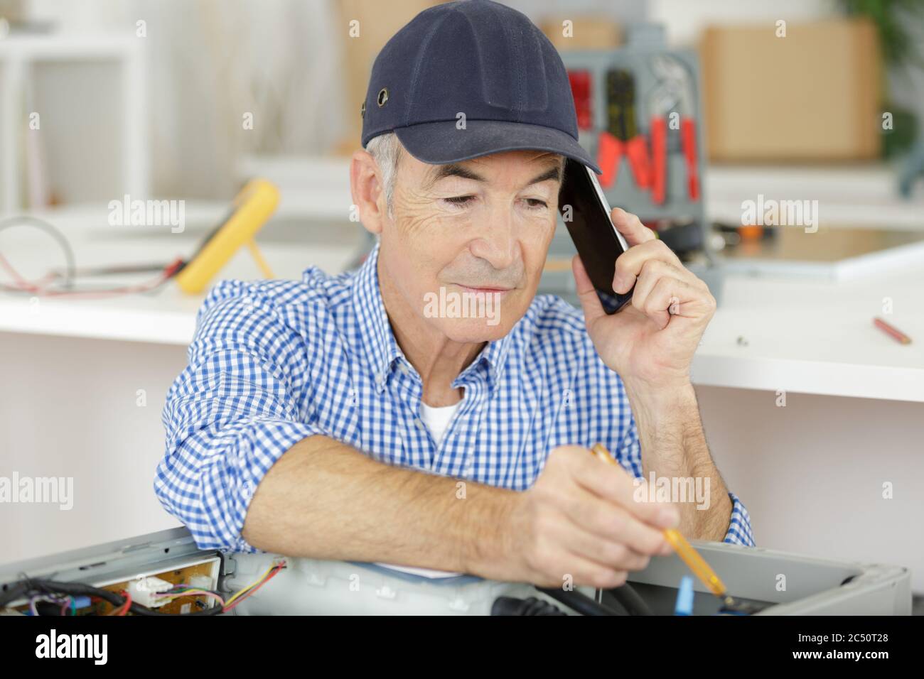 senior man fixing electric plug Stock Photo - Alamy