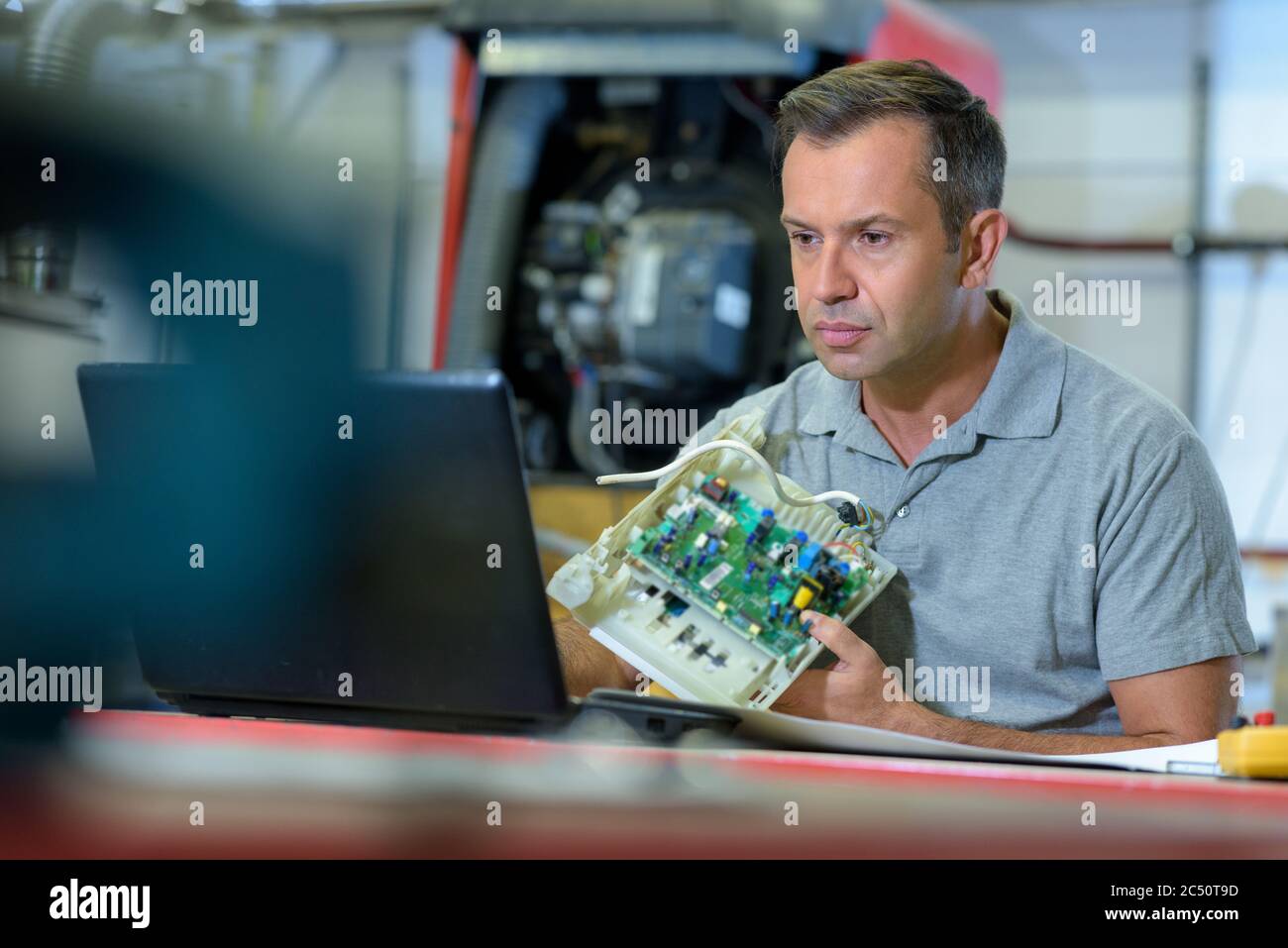 man holding computer motherboard and working on laptop Stock Photo - Alamy