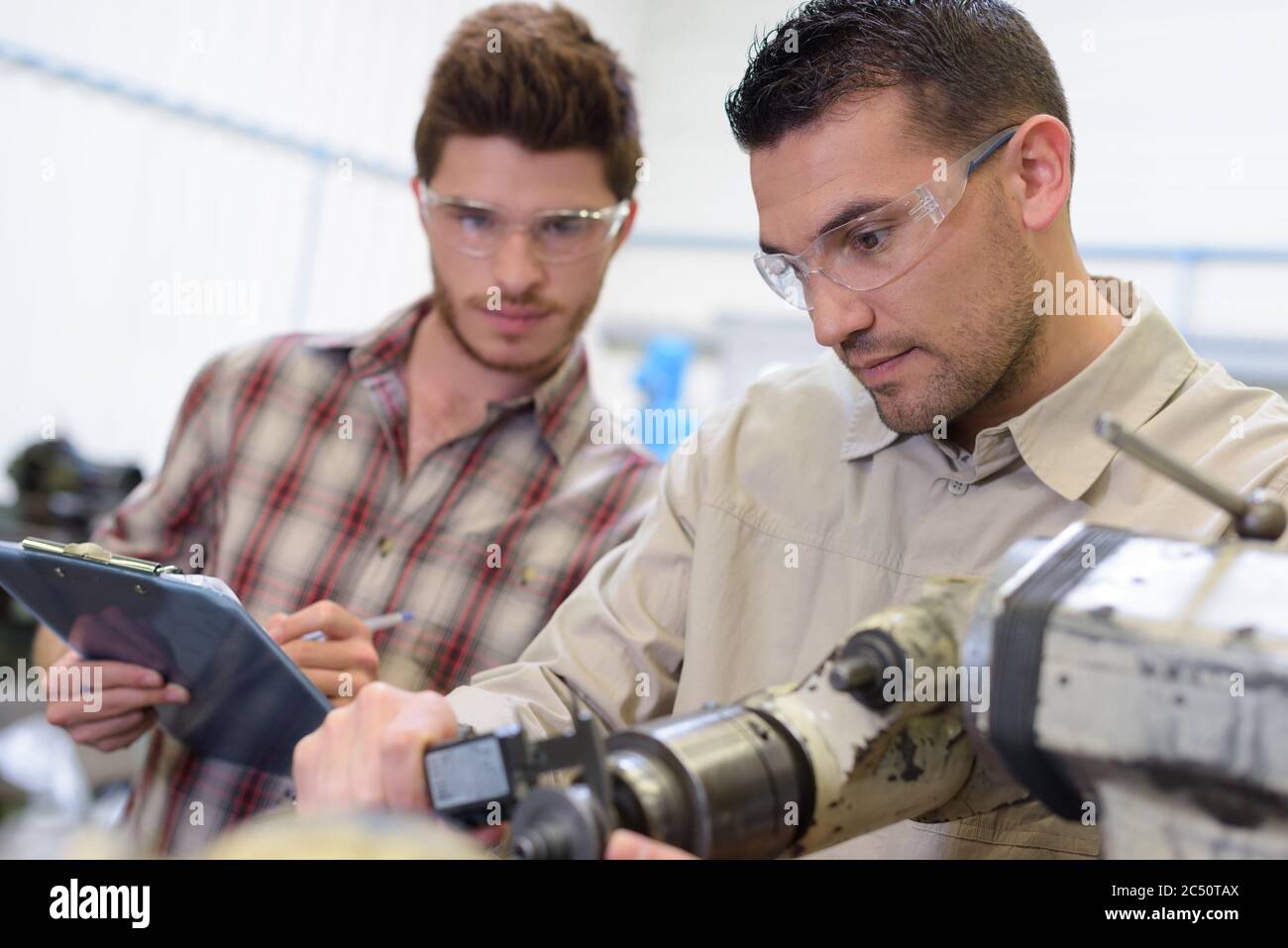 two men working at a factory Stock Photo - Alamy