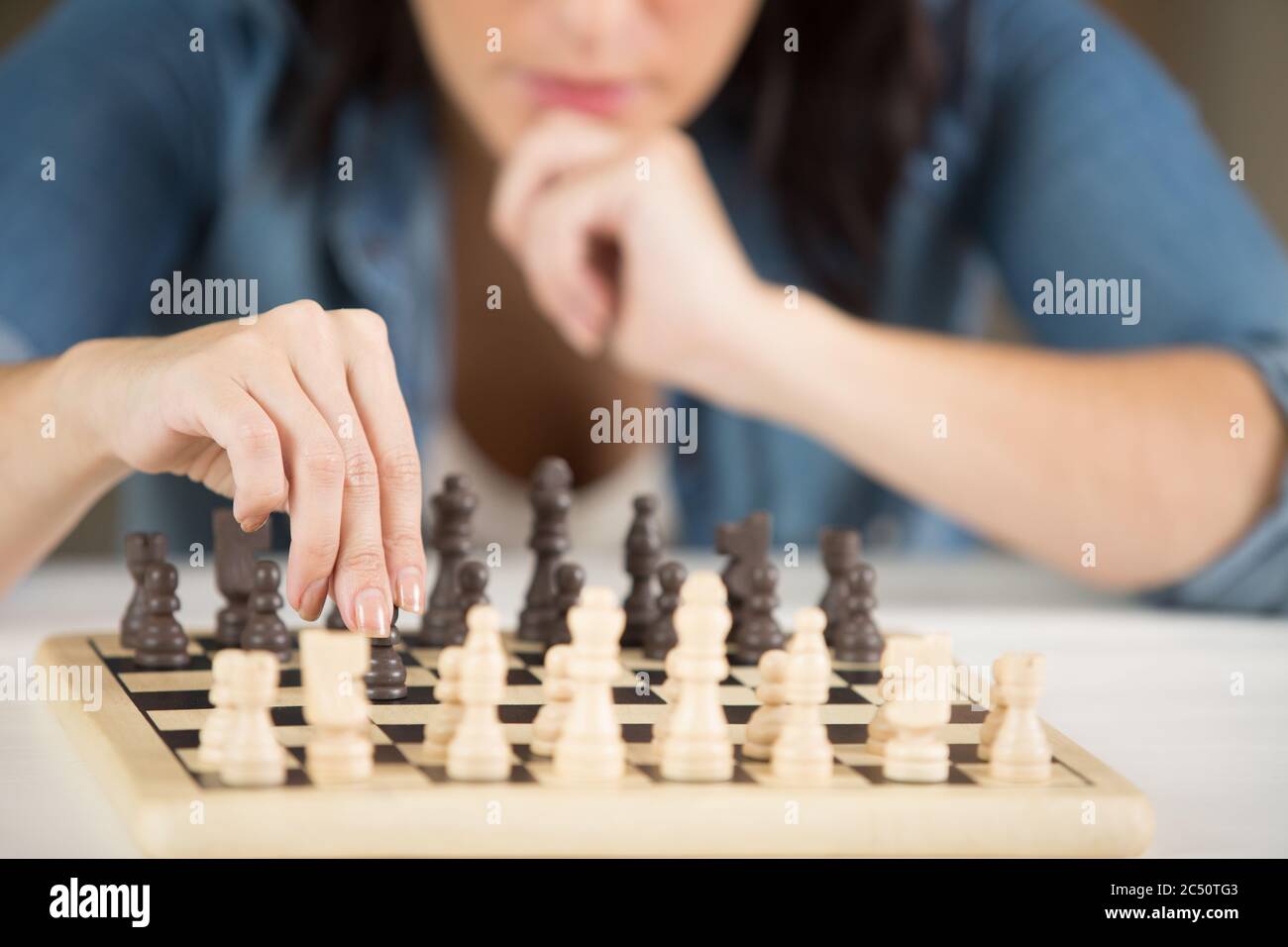 woman playing chess indoor and thinking position Stock Photo - Alamy