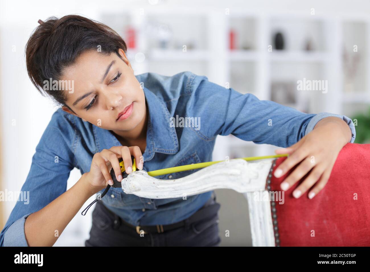 young woman measuring a chair Stock Photo - Alamy