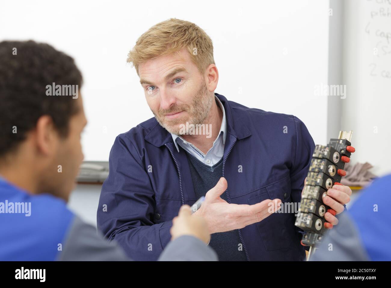 teacher showing an object to the apprentice Stock Photo - Alamy