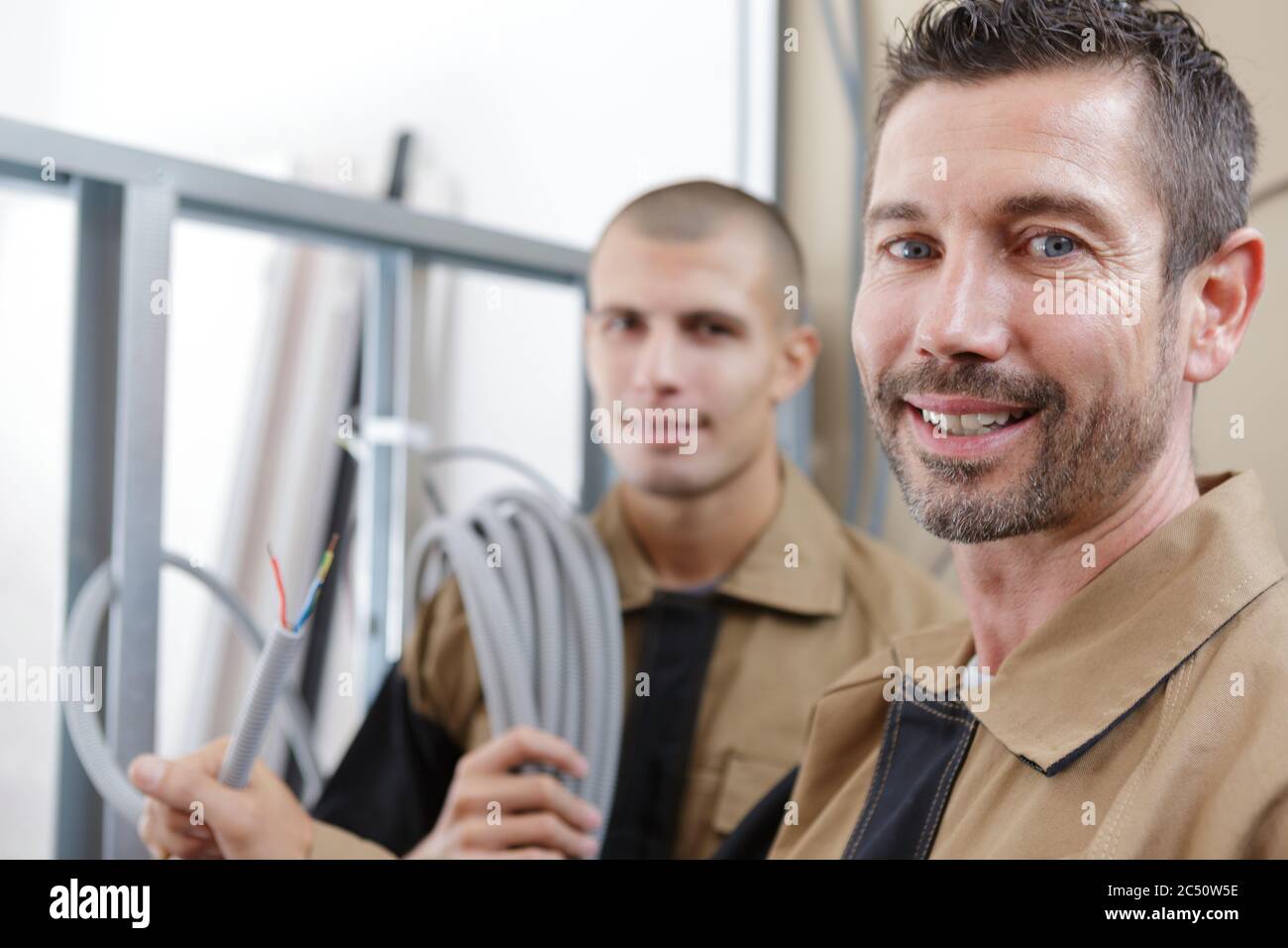 installation of electrical wiring to workers Stock Photo - Alamy