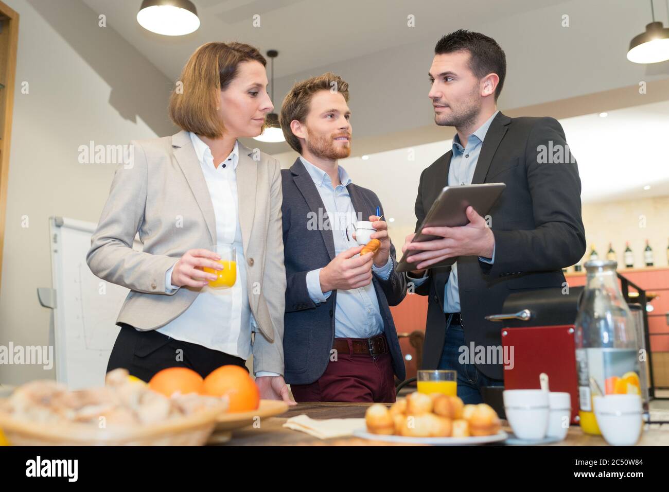 group of business people having breakfast together in office Stock ...