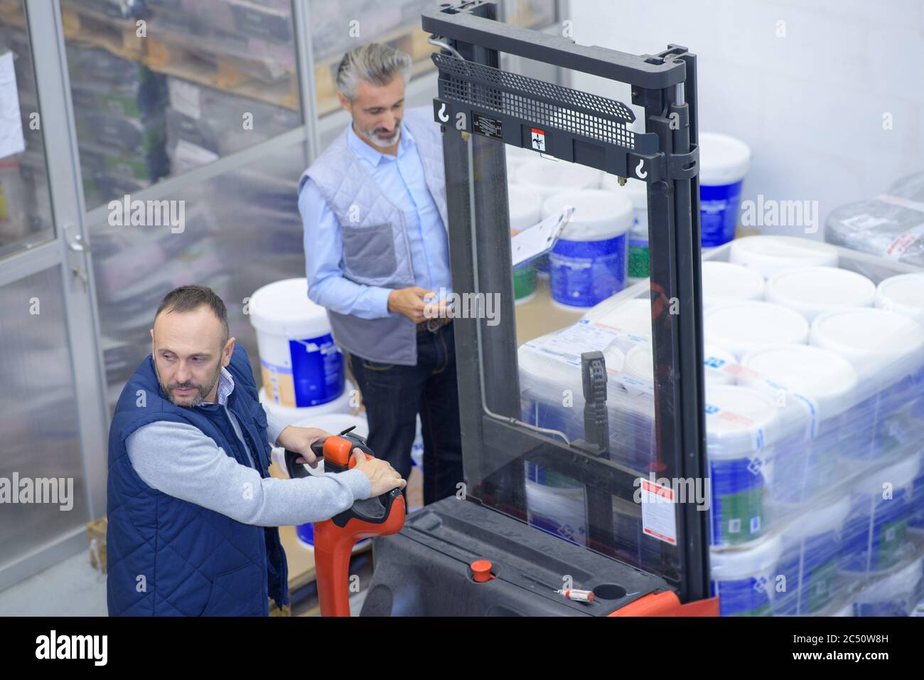 Worker moving pallet of plastic containers Stock Photo - Alamy