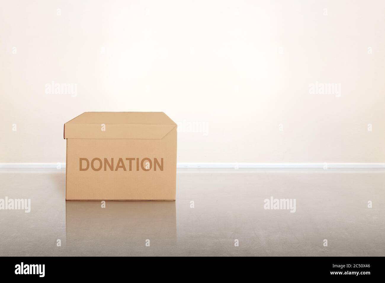 Donation box for collecting donations on the floor with white wall ...