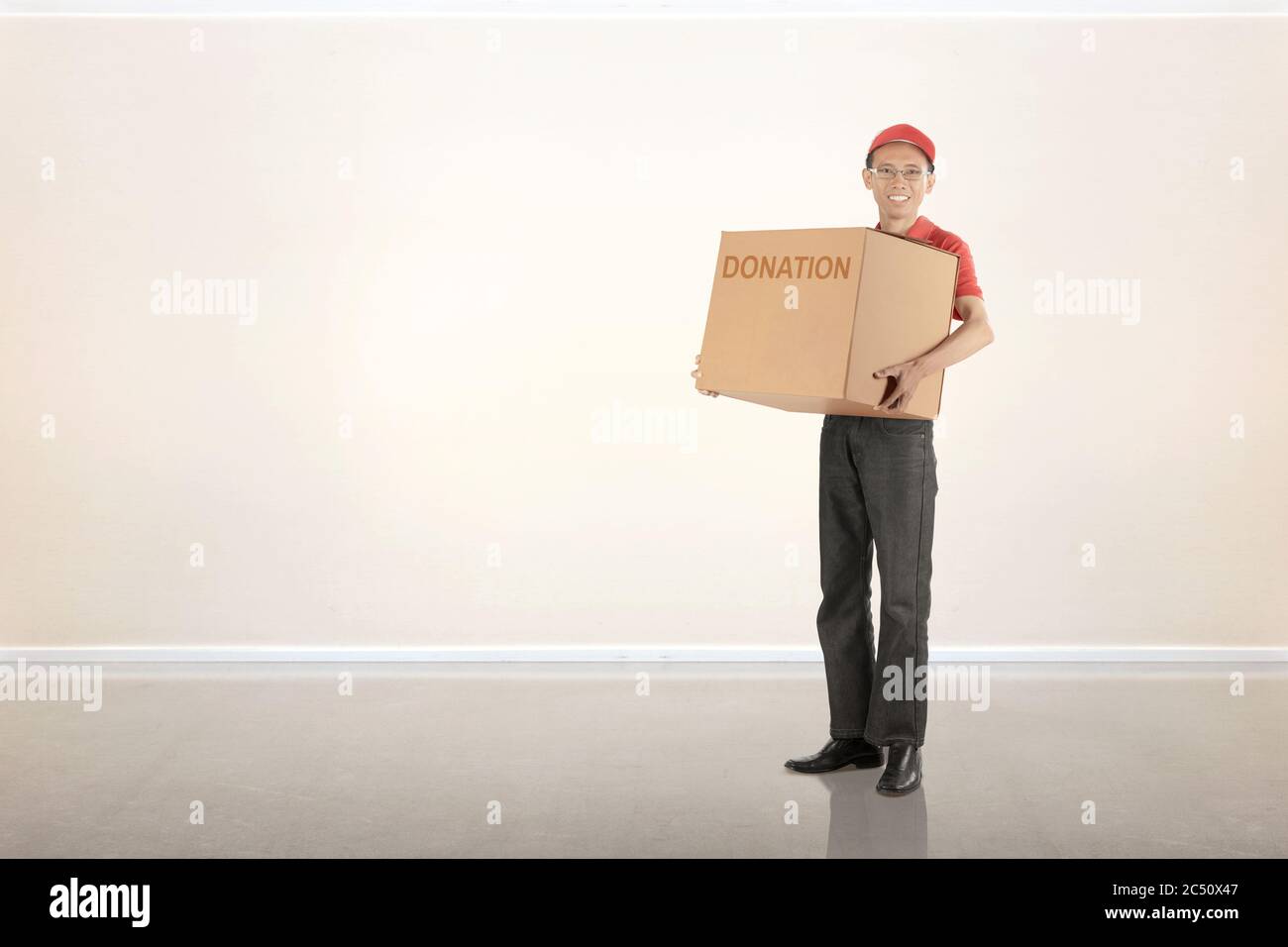 Asian man carrying box with donation text to collecting donations ...