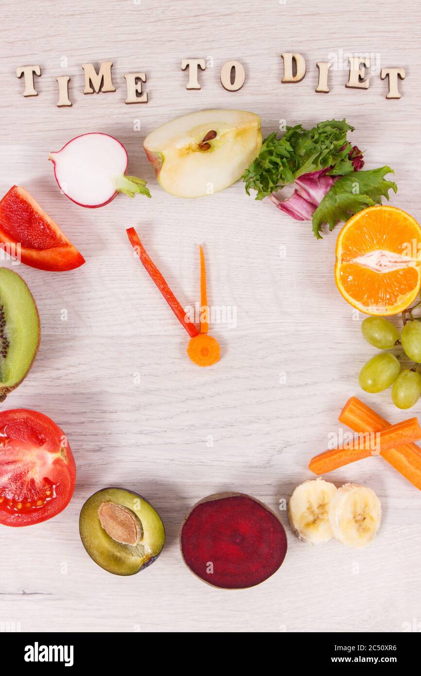 Fresh ripe fruits and vegetables in shape of clock showing time to diet ...