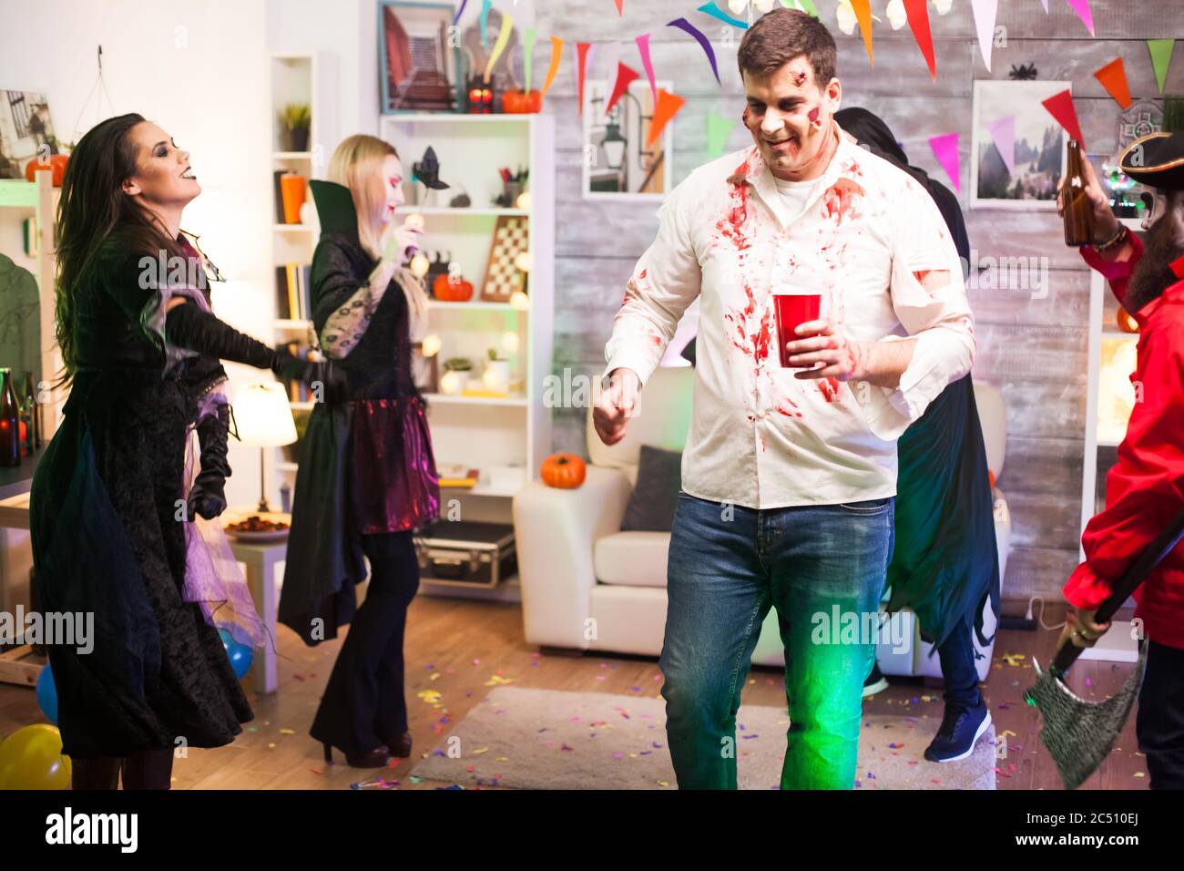 Man dressed up like a zombie drinking beer while celebrating halloween ...