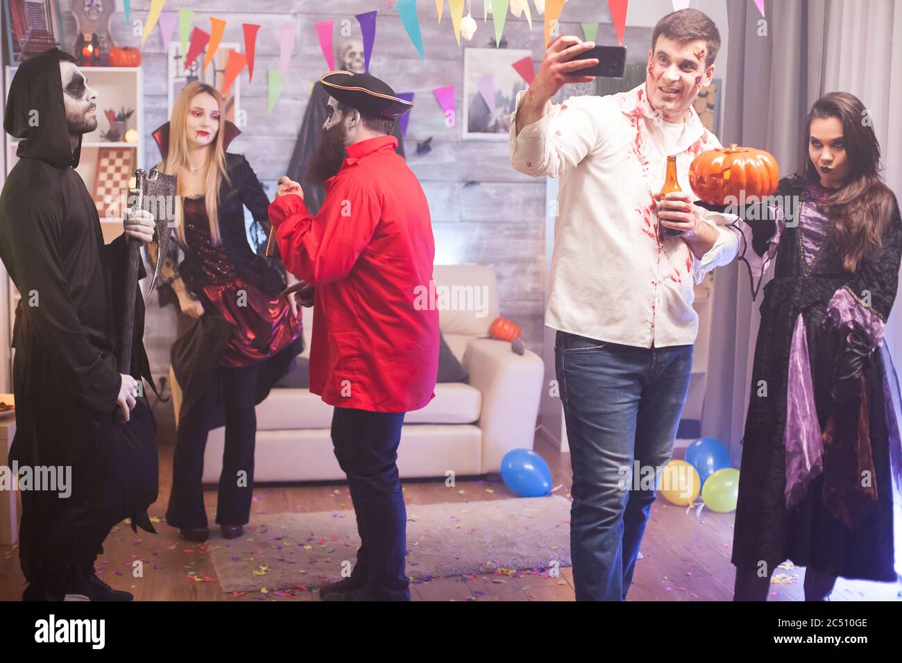 Spooky zombie and witch are taking a selfie while celebrating halloween ...