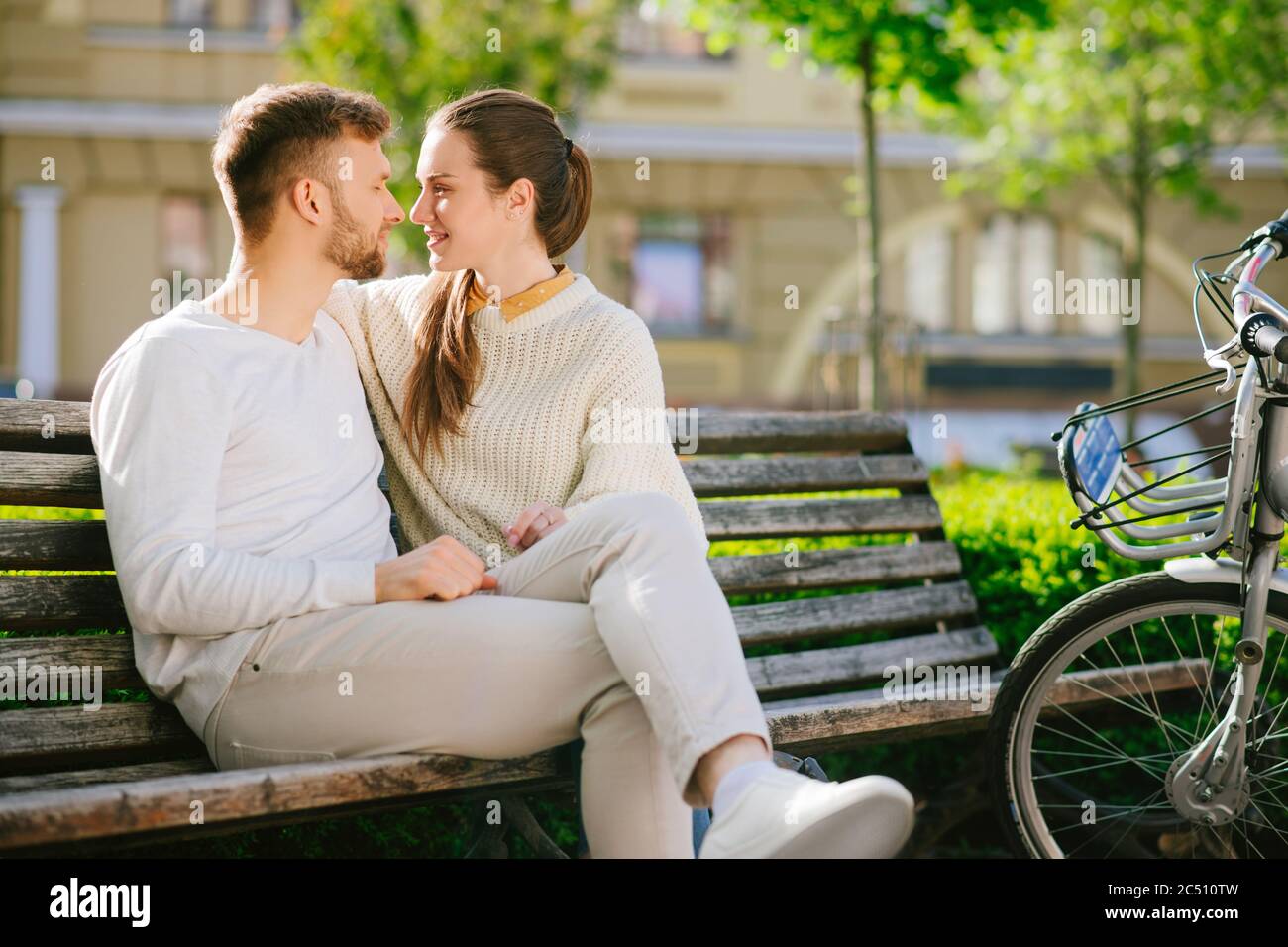 Woman and man sitting on a bench face to face Stock Photo - Alamy