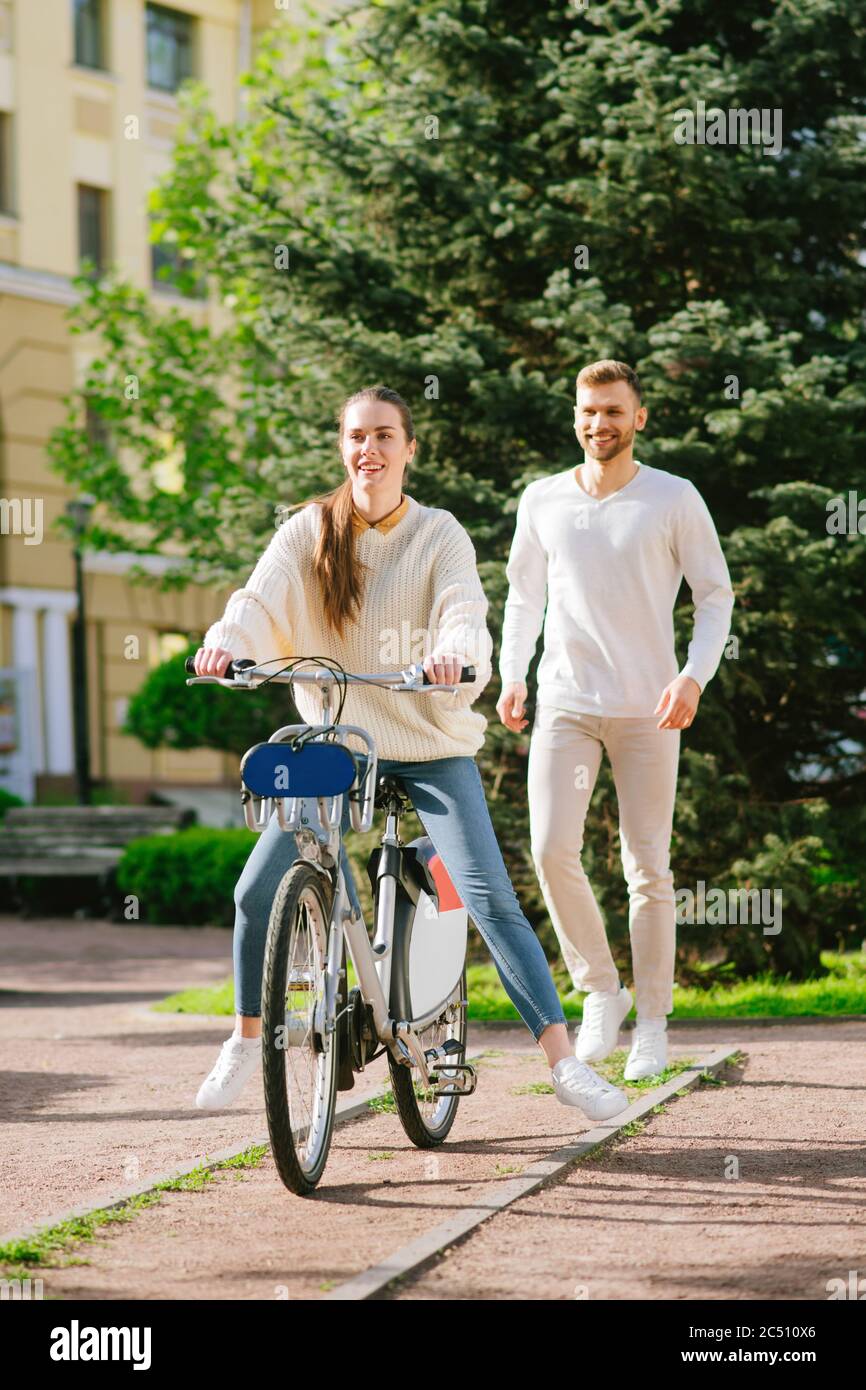Woman riding a bicycle and man running from behind Stock Photo - Alamy