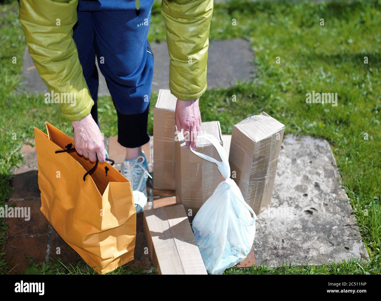 A woman tring to lift shopping bags, outdoor cropped shot Stock Photo ...