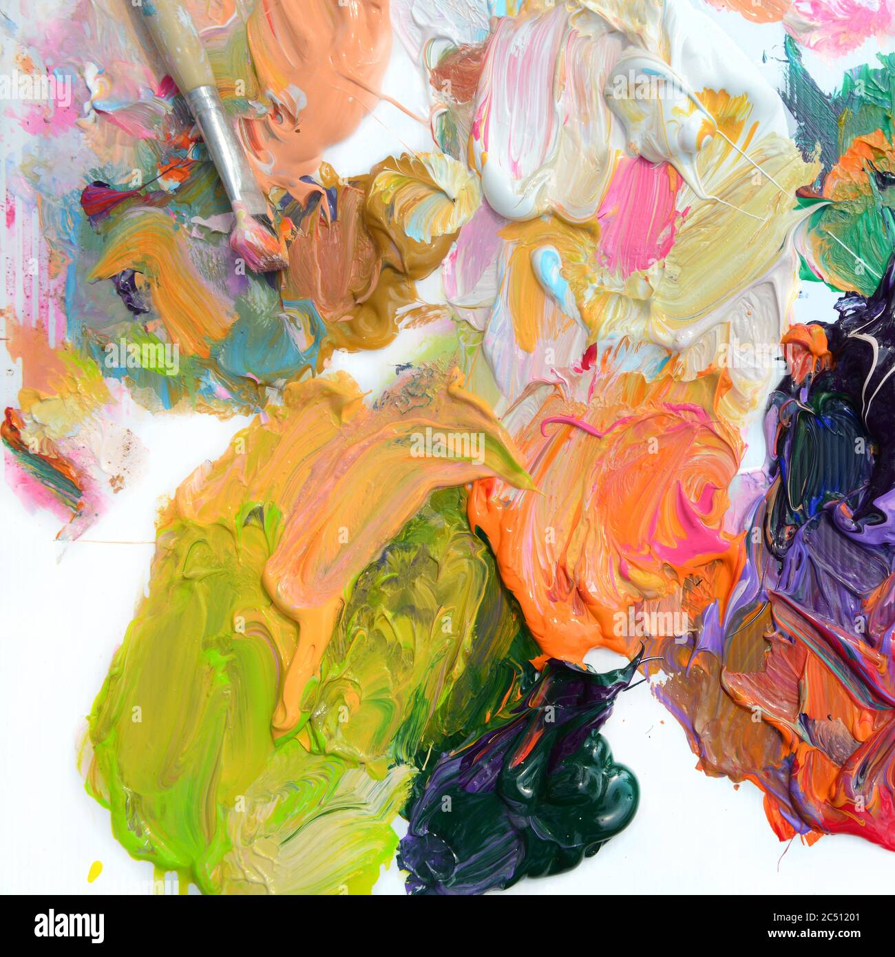 Colorful oil paint of different colors on a palette and brushes on ...