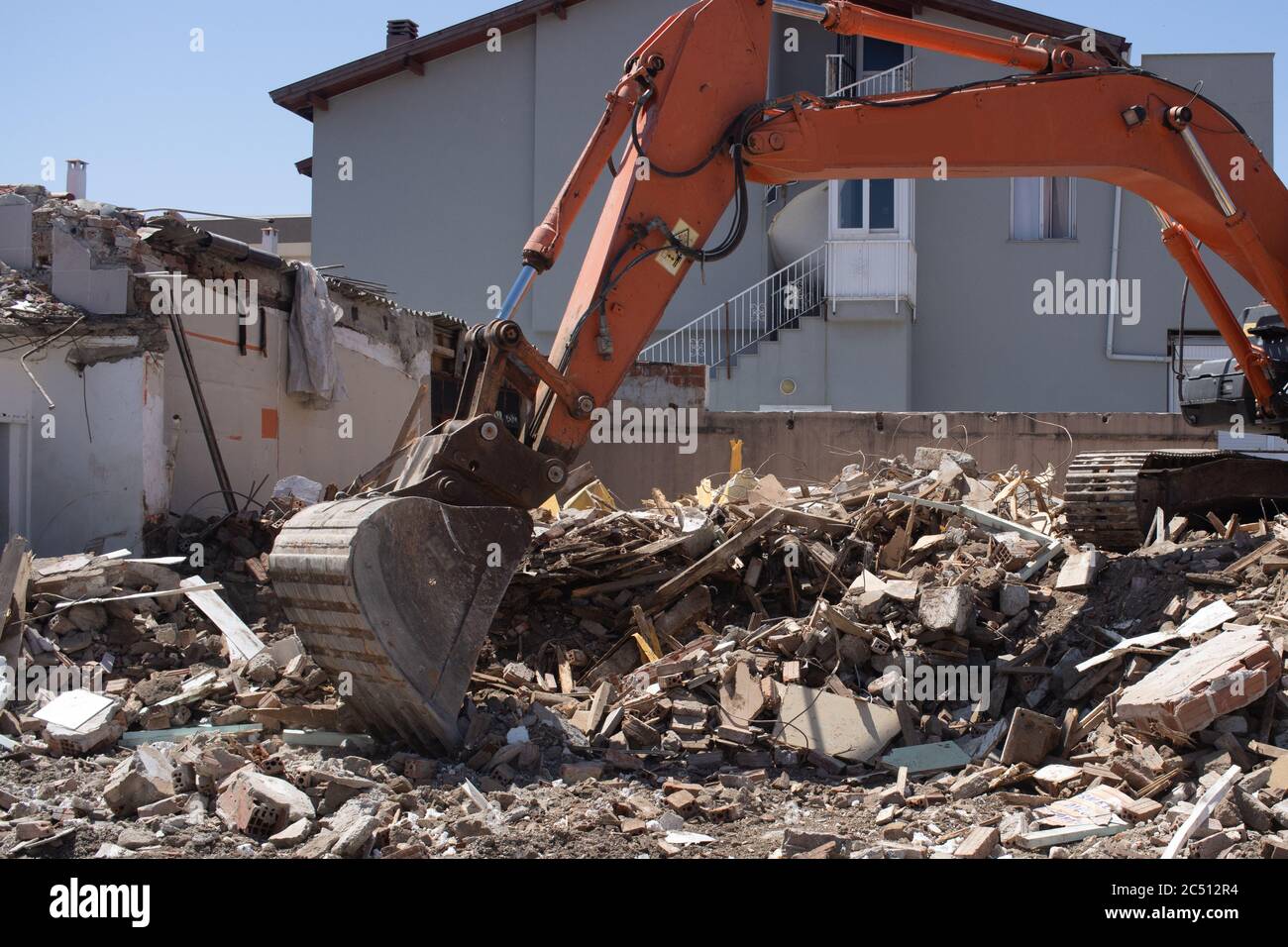 excavator loading debris of a destroyed building Stock Photo - Alamy