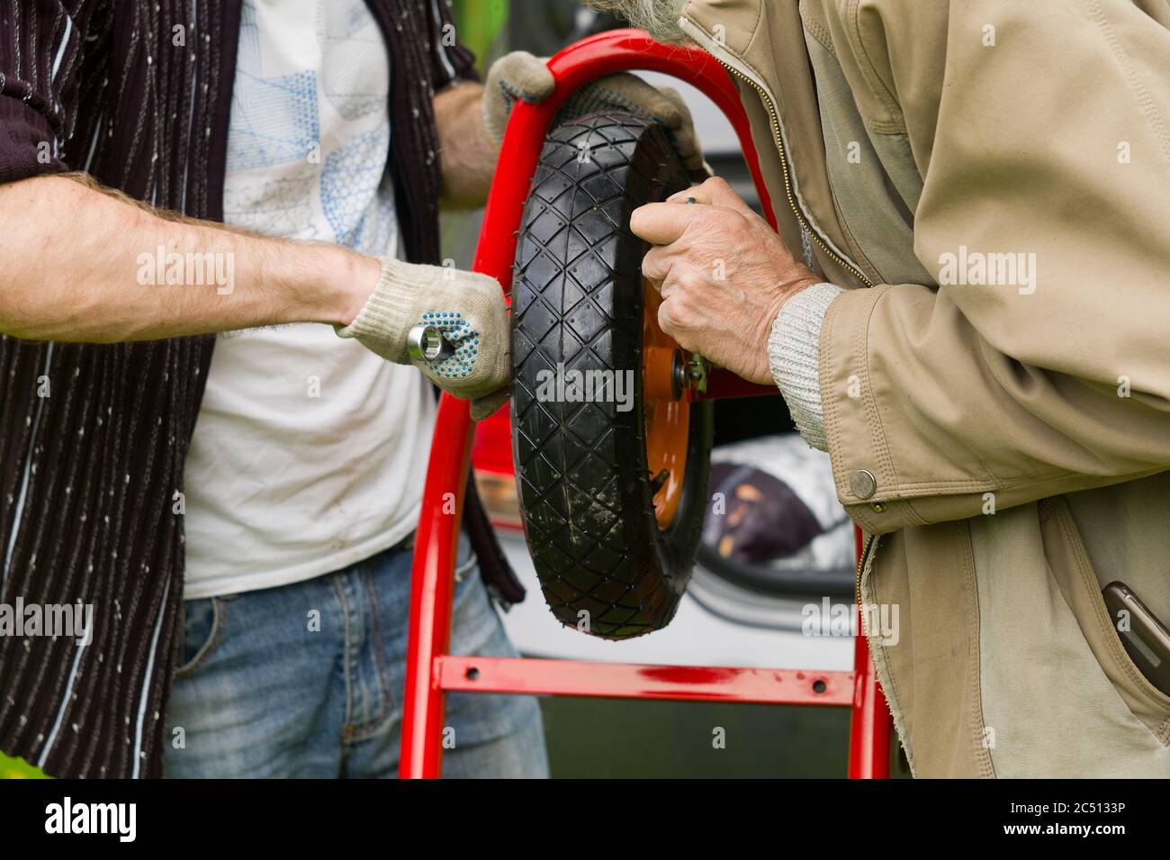 People changing tire on a tgarden rolley, outdoor closeup Stock Photo ...