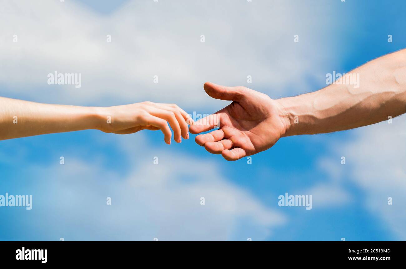 Hands of man and woman on blue sky background. Lending a helping hand ...