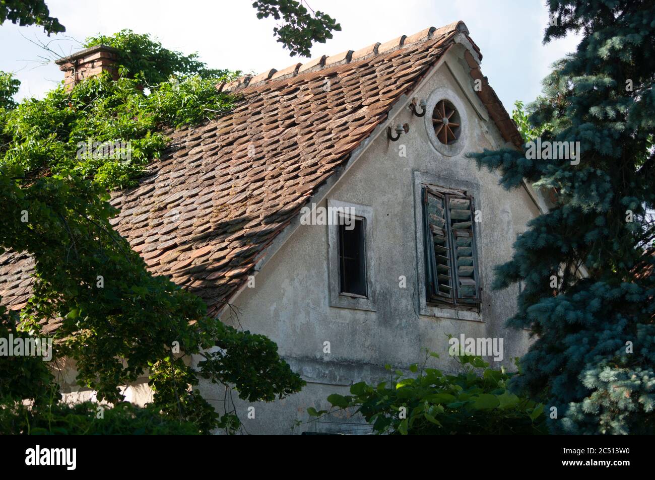 Attic tiled roof of an old house, window with shutters. Slovenia Stock ...