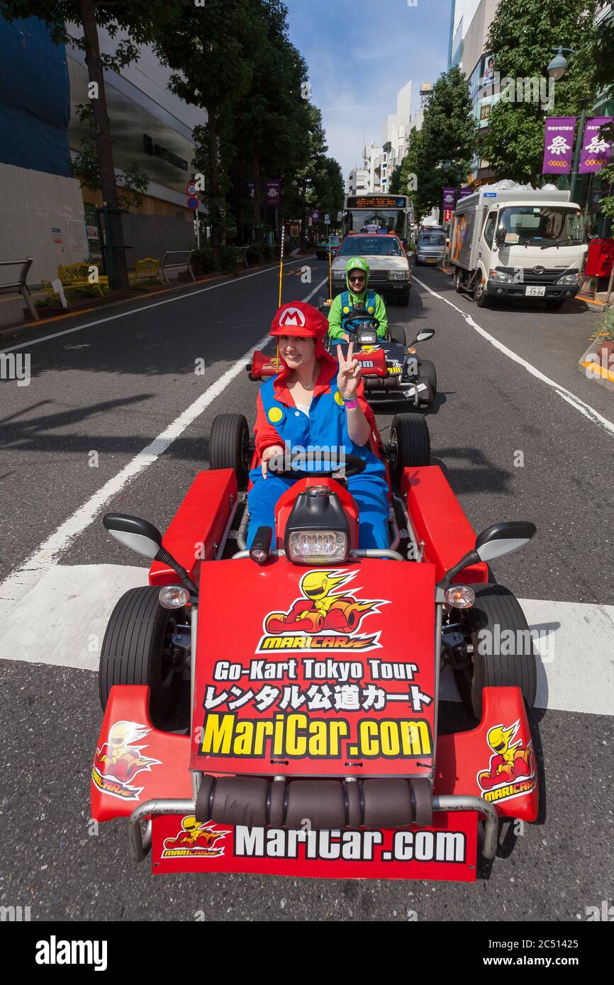 Western tourists enjoy touring the streets of Tokyo on go carts ...