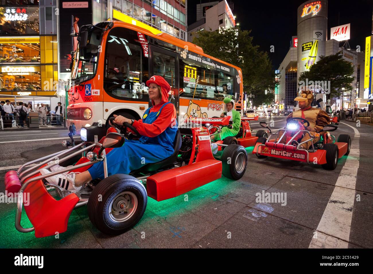 Western tourists enjoy touring the streets of Tokyo on go carts ...