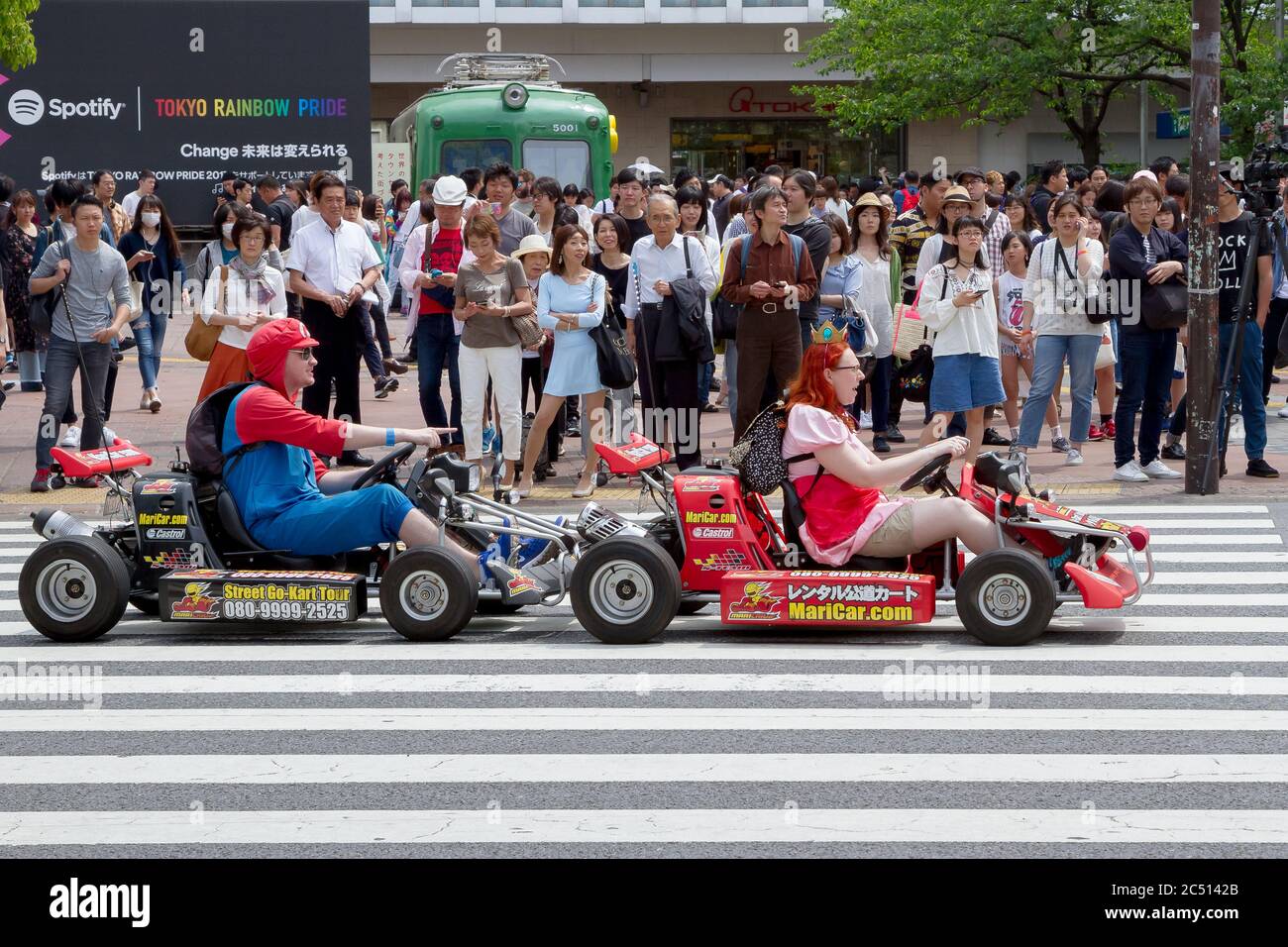 Western tourists enjoy touring the streets of Tokyo on go carts ...