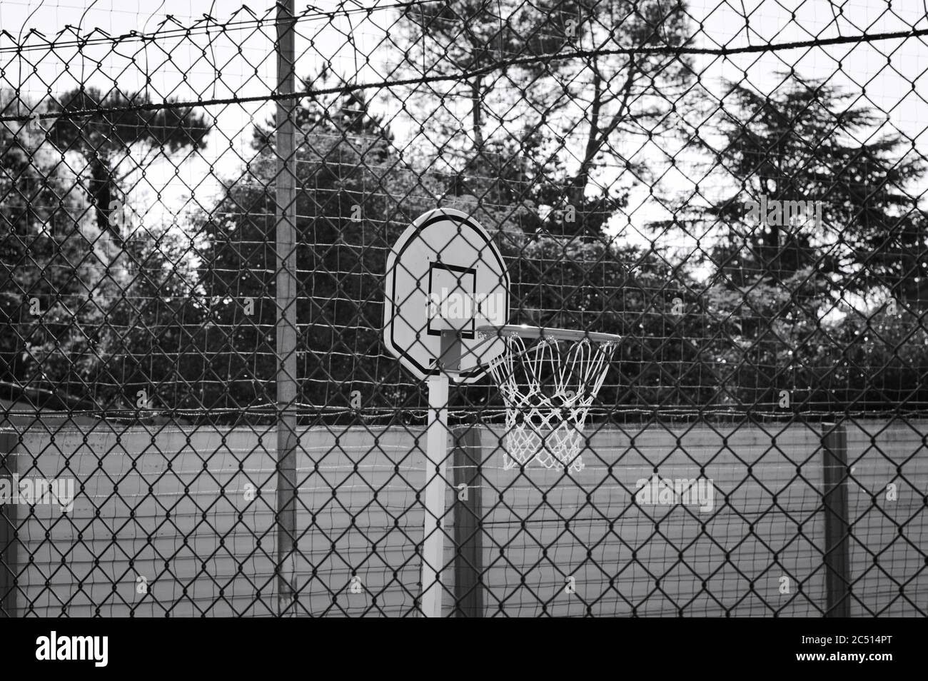 Basketball hoop in a playground behind a metallic fence (Pesaro, Italy ...