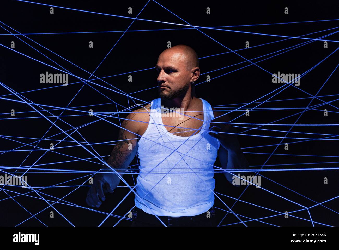 Photo of bald man tangled in white threads in neon light Stock Photo ...