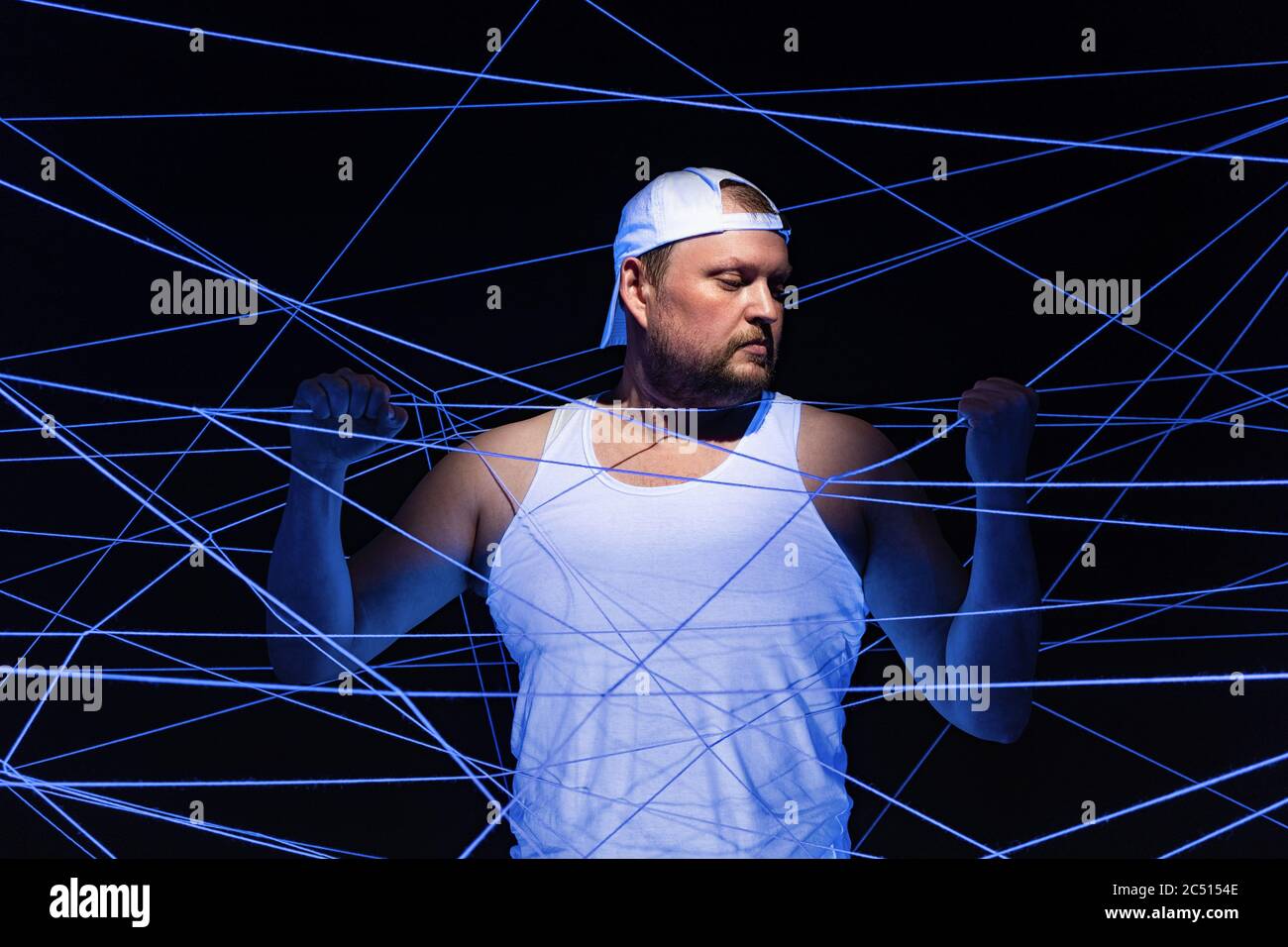 Photo of stout man with white threads in neon light Stock Photo - Alamy