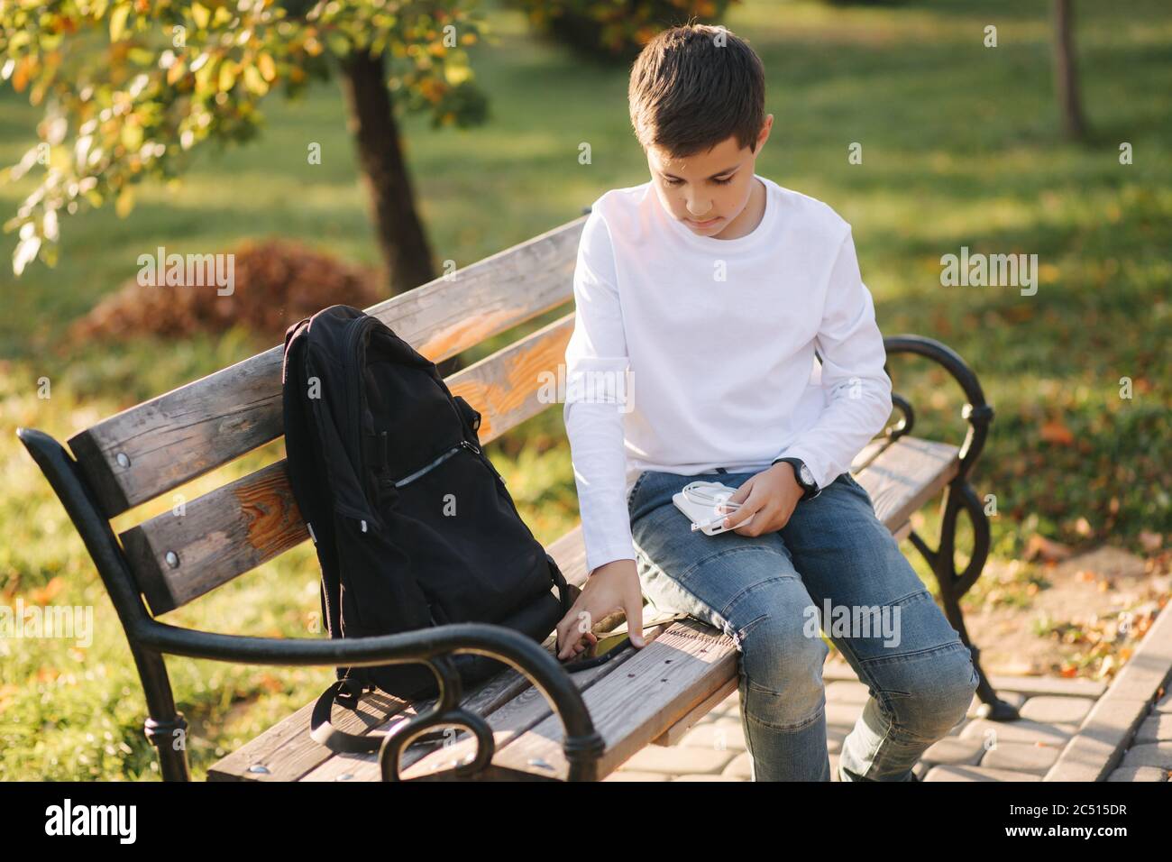 Handsome teenage boy take from his backpack powerbark for charging ...