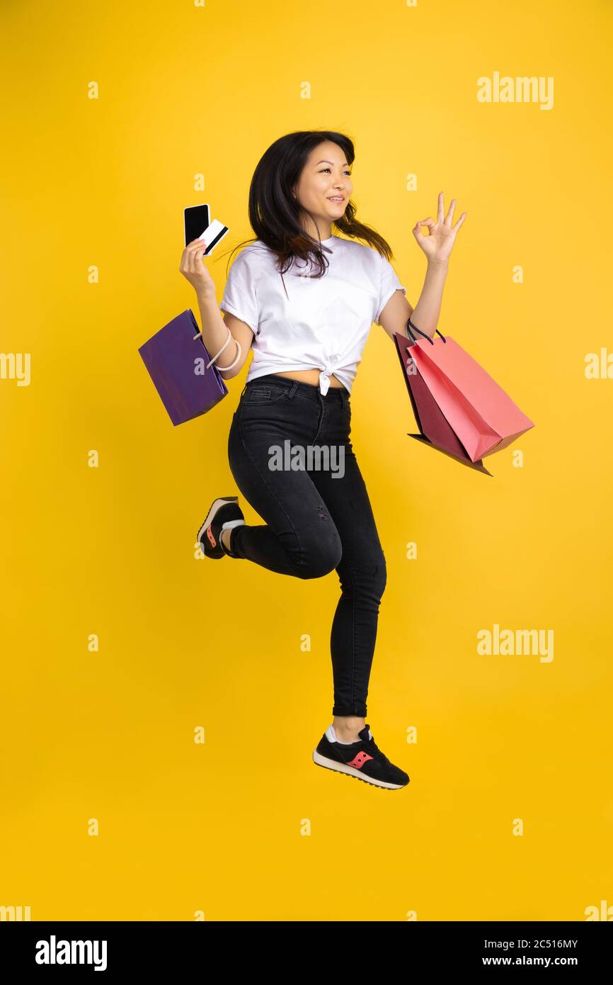 Online purchase. Young asian woman with colorful shopping packages on ...