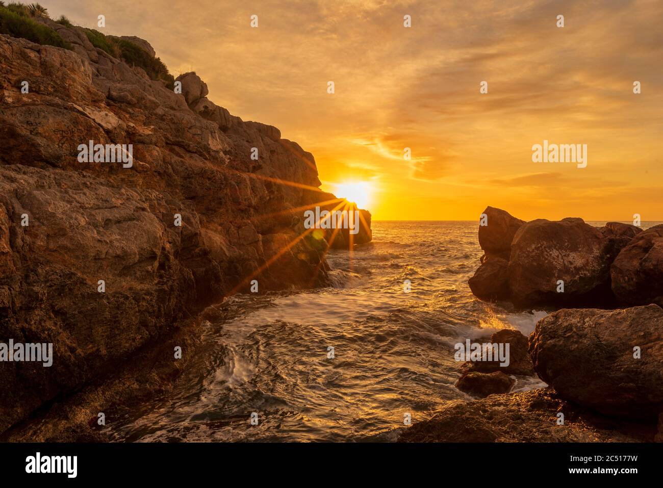 Sunrise between the rocks of the renega in Oropesa, Spain Stock Photo ...
