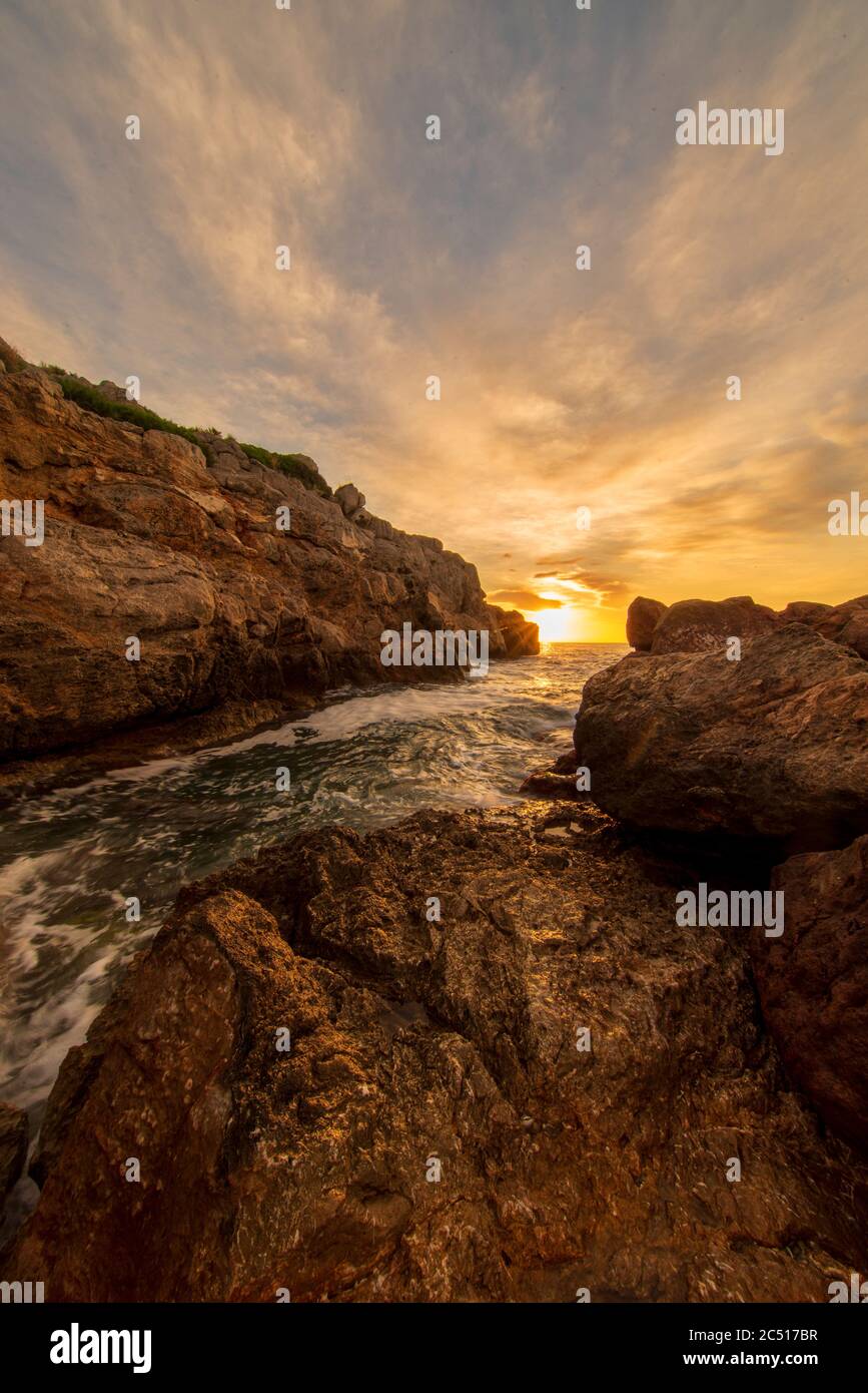 Sunrise between the rocks of the renega in Oropesa, Spain Stock Photo ...