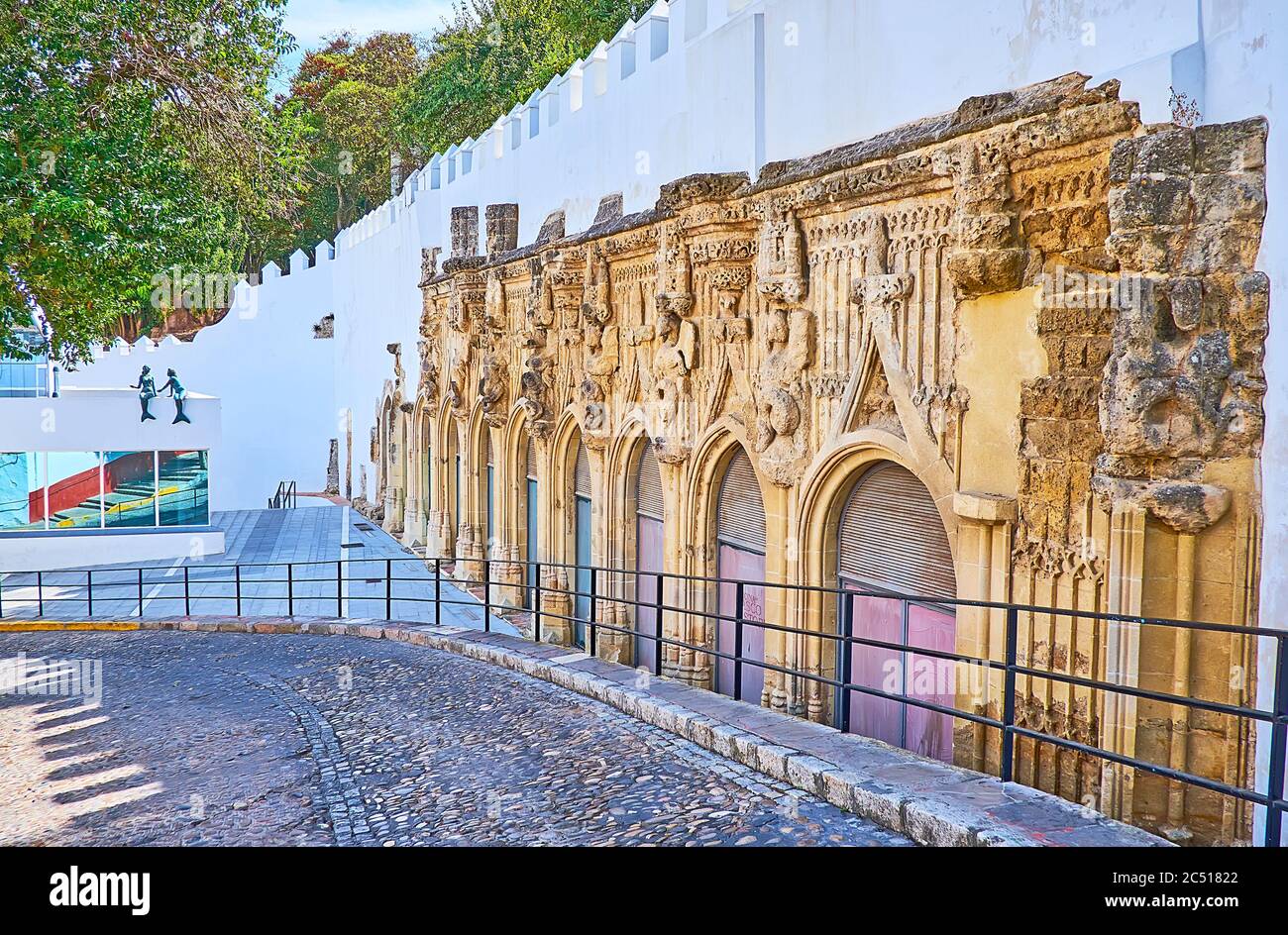 The tall wall of Duke Medina Sidonia palace with line of Las Covachas ...