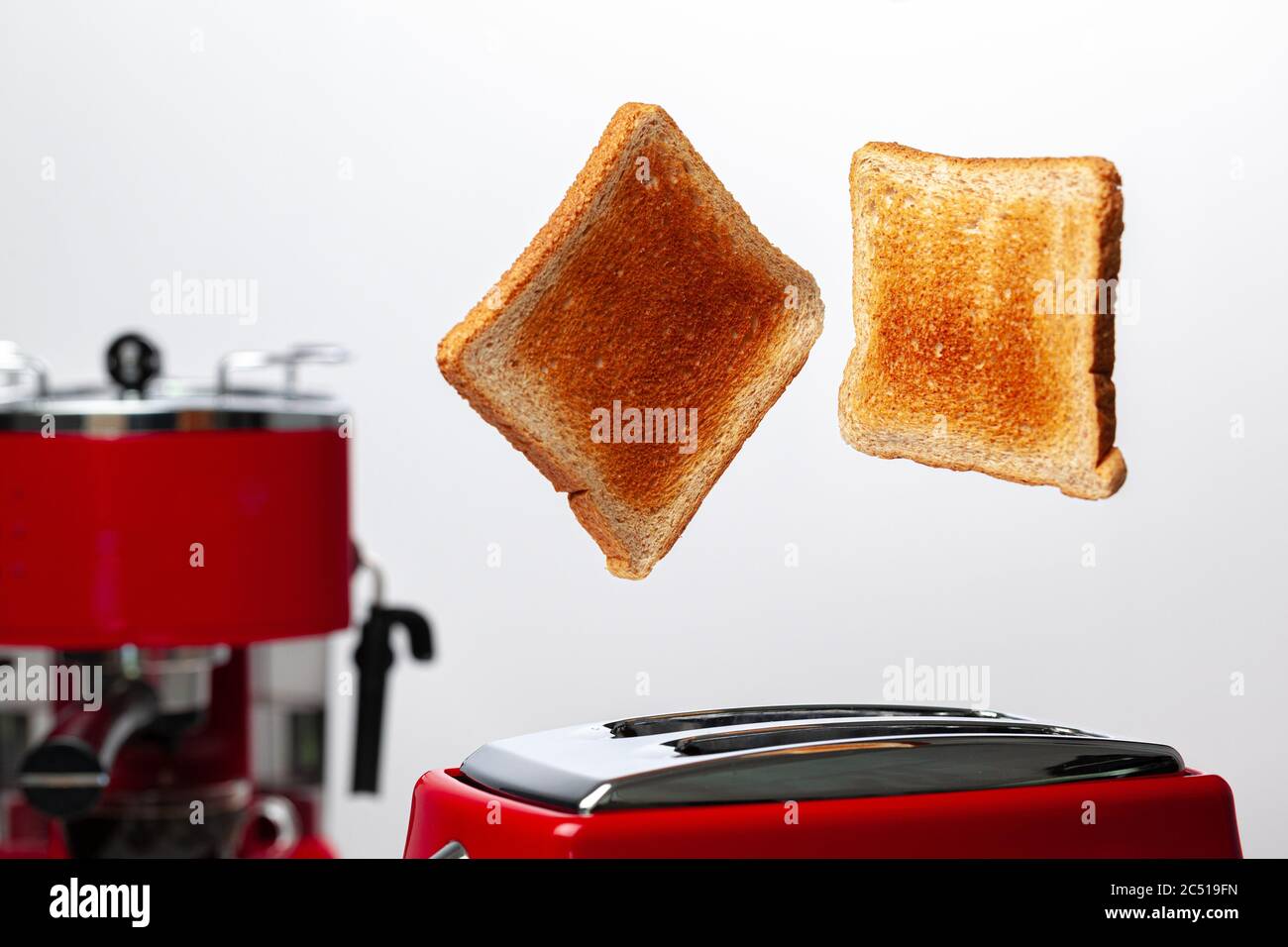 Two toasts jumping out of red toaster against white background Stock ...