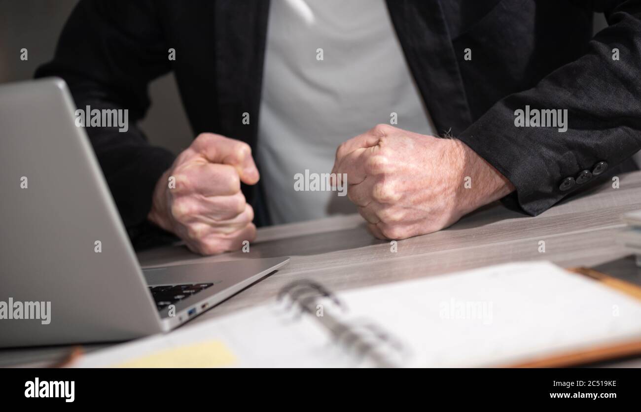 Angry businessman hitting his desk with his clenched fists Stock Photo ...