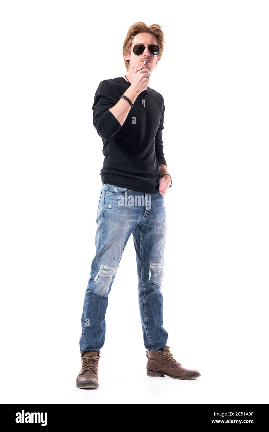 Confident macho male smoker lighting up rolled cigarette using lighter ...