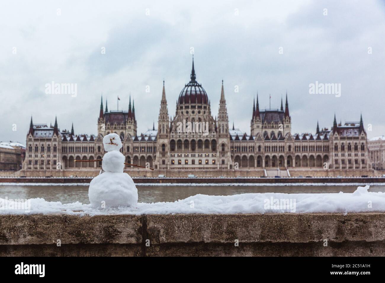 Hungarian parliament building at winter with snow. Snowman on the river ...