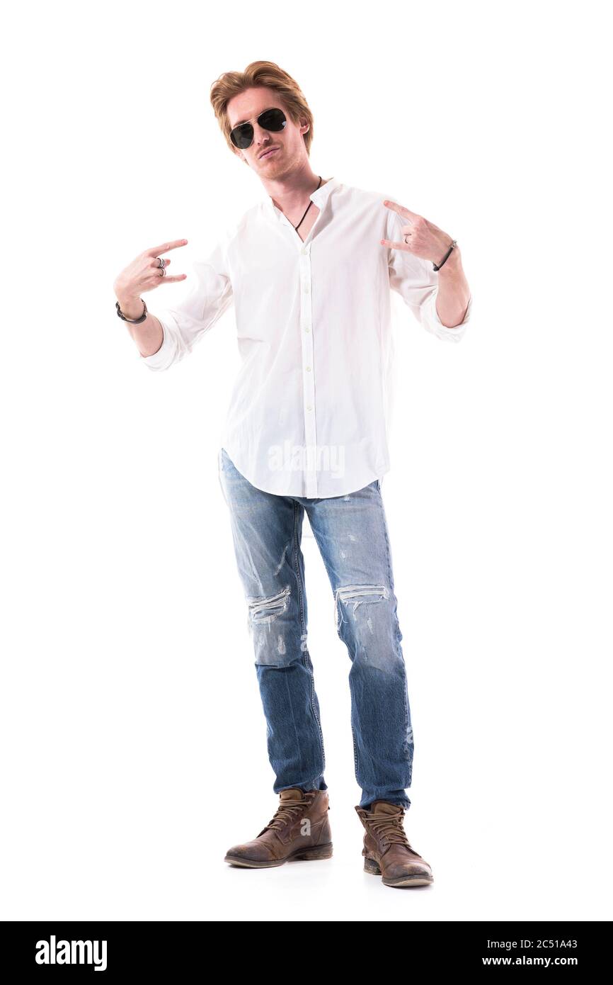 Young serious handsome stylish man showing heavy metal horns sign. Full ...