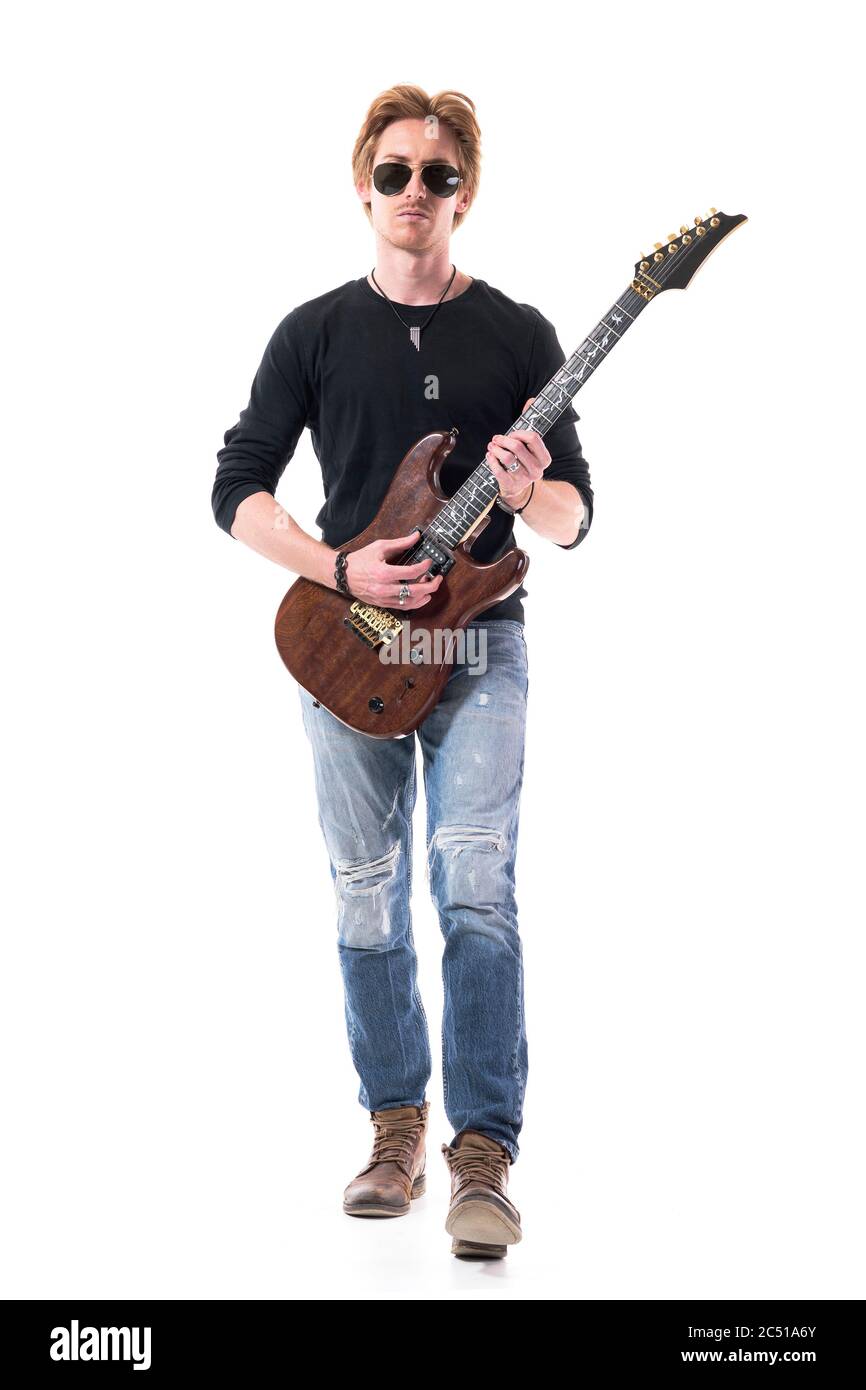 Handsome young red hair rocker stepping forward playing electric guitar ...
