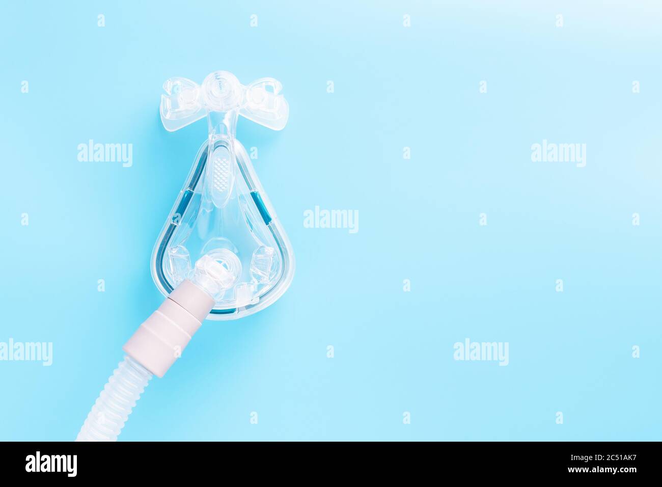 CPAP mask on blue background with copy space. Sleep apnea treatment ...