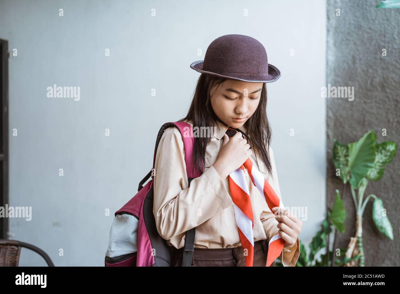 indonesian girl scout getting ready to go preparing her uniform at home ...