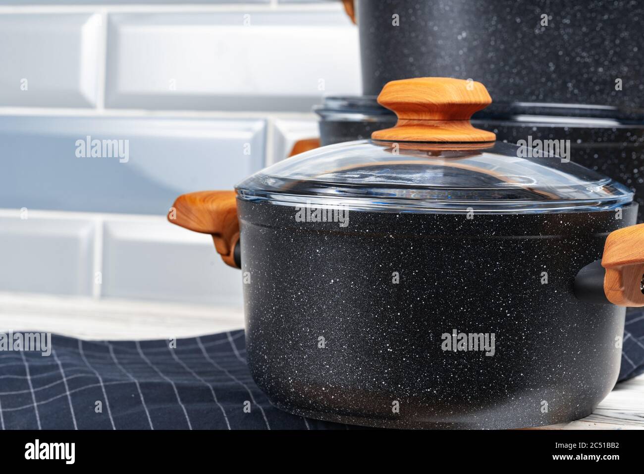 New black cookware with wooden handles close up Stock Photo - Alamy
