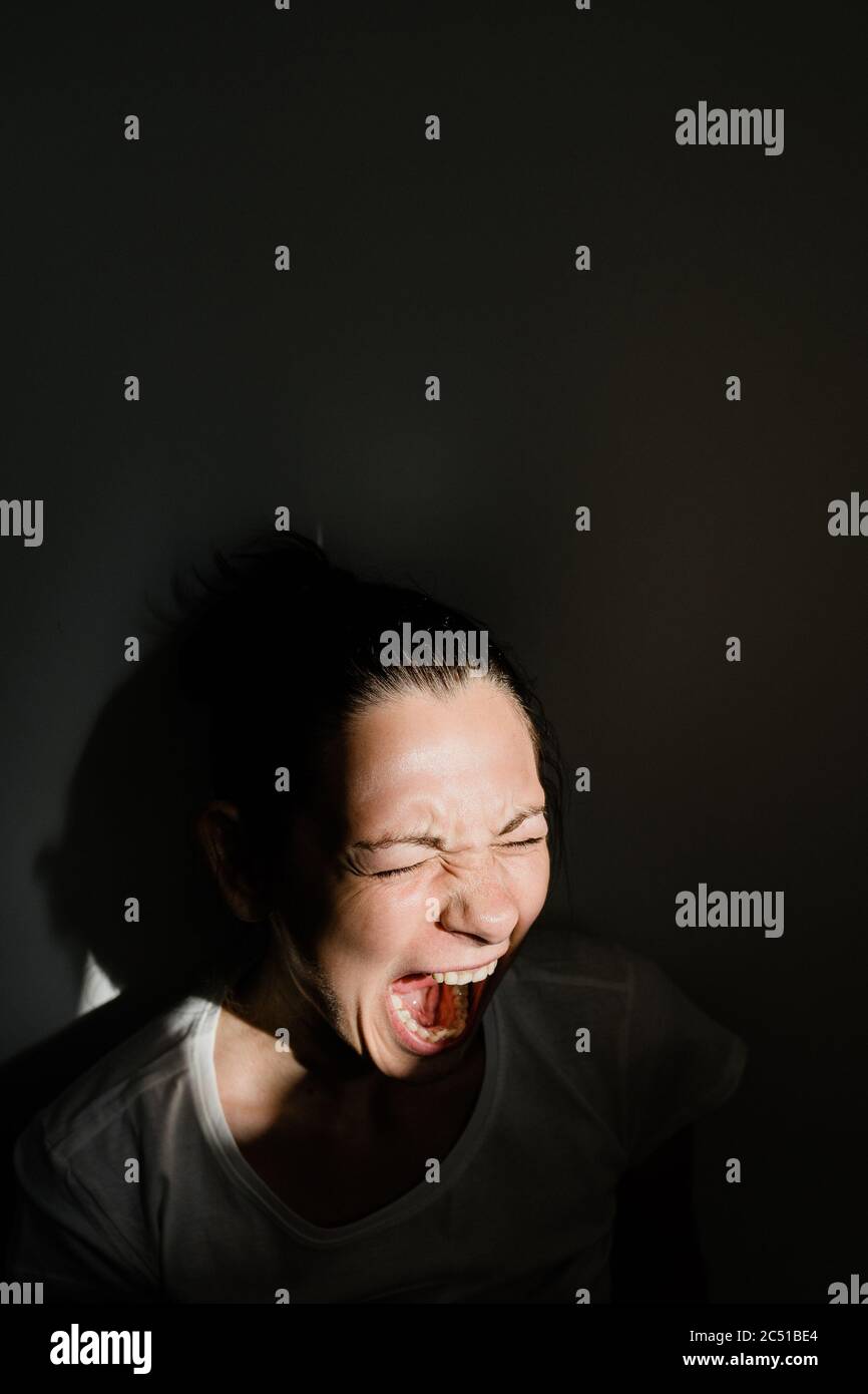 Caucasian woman screaming in sunlight. Black shadows. Mental health ...