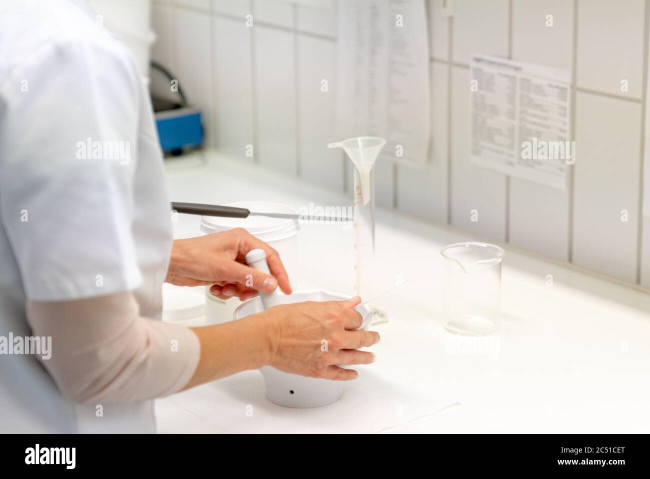 A close up view of a pharmacist in the laboratory mixing a medical ...