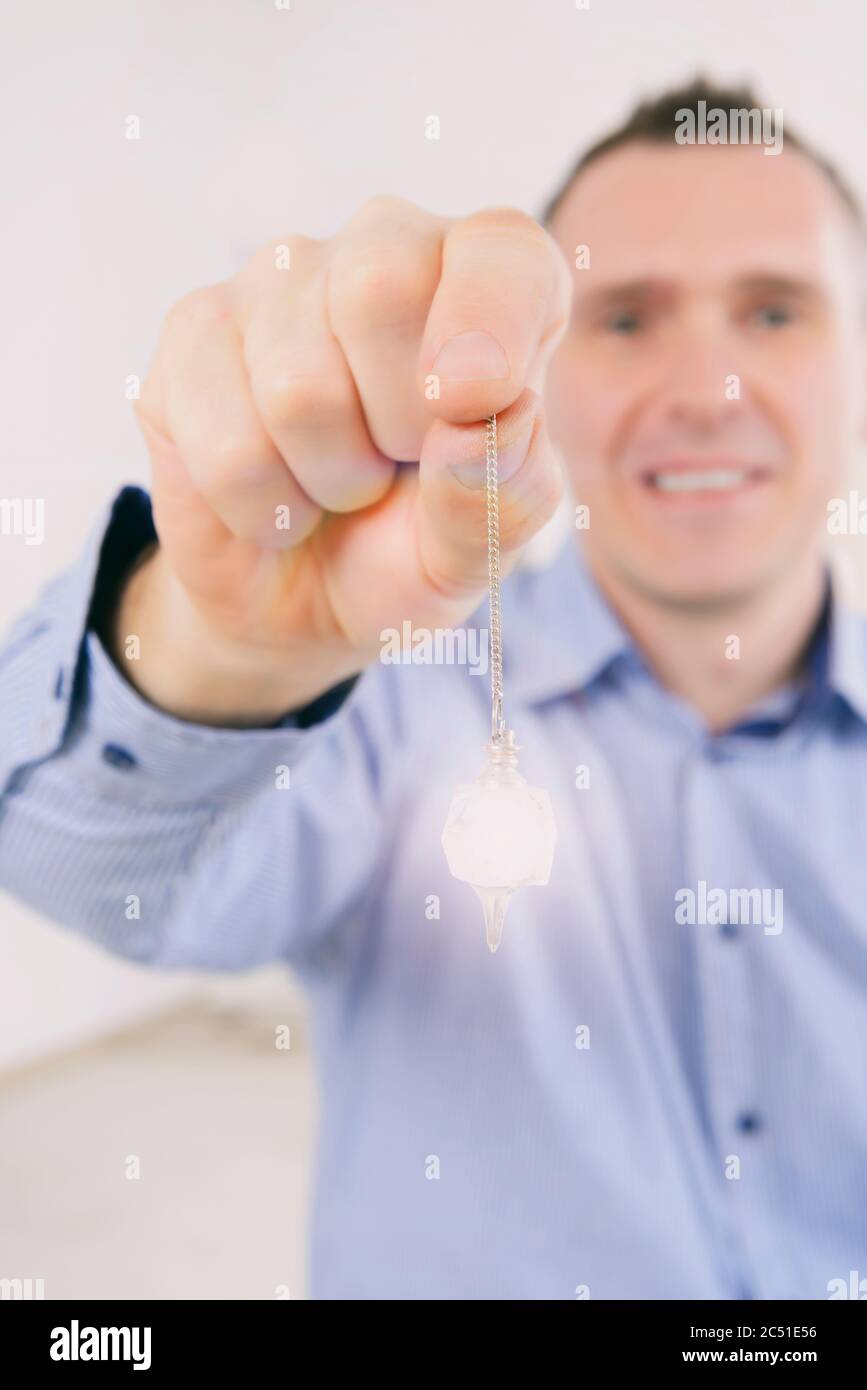 Hand with pendulum, tool for dowsing Stock Photo - Alamy