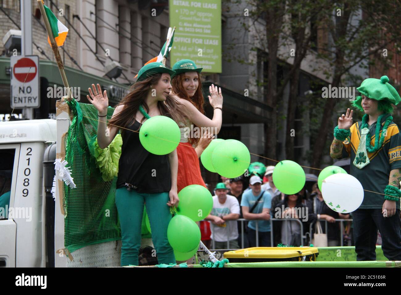 Irish girls and a boy on a float wave to people watching the St Patrick ...
