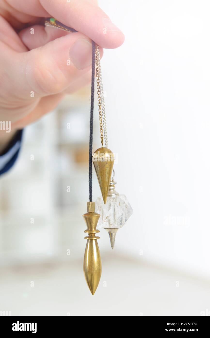 Hand with many pendulums pink crystal pendulum, copper, karnak, tool ...