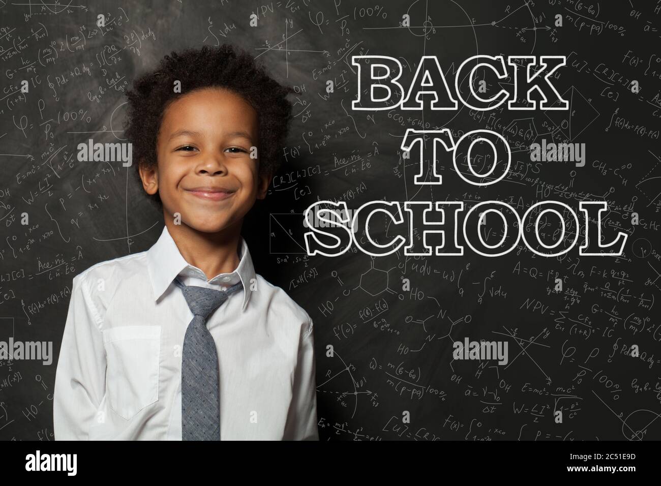 Happy smart African American child student with chalk science formulas ...